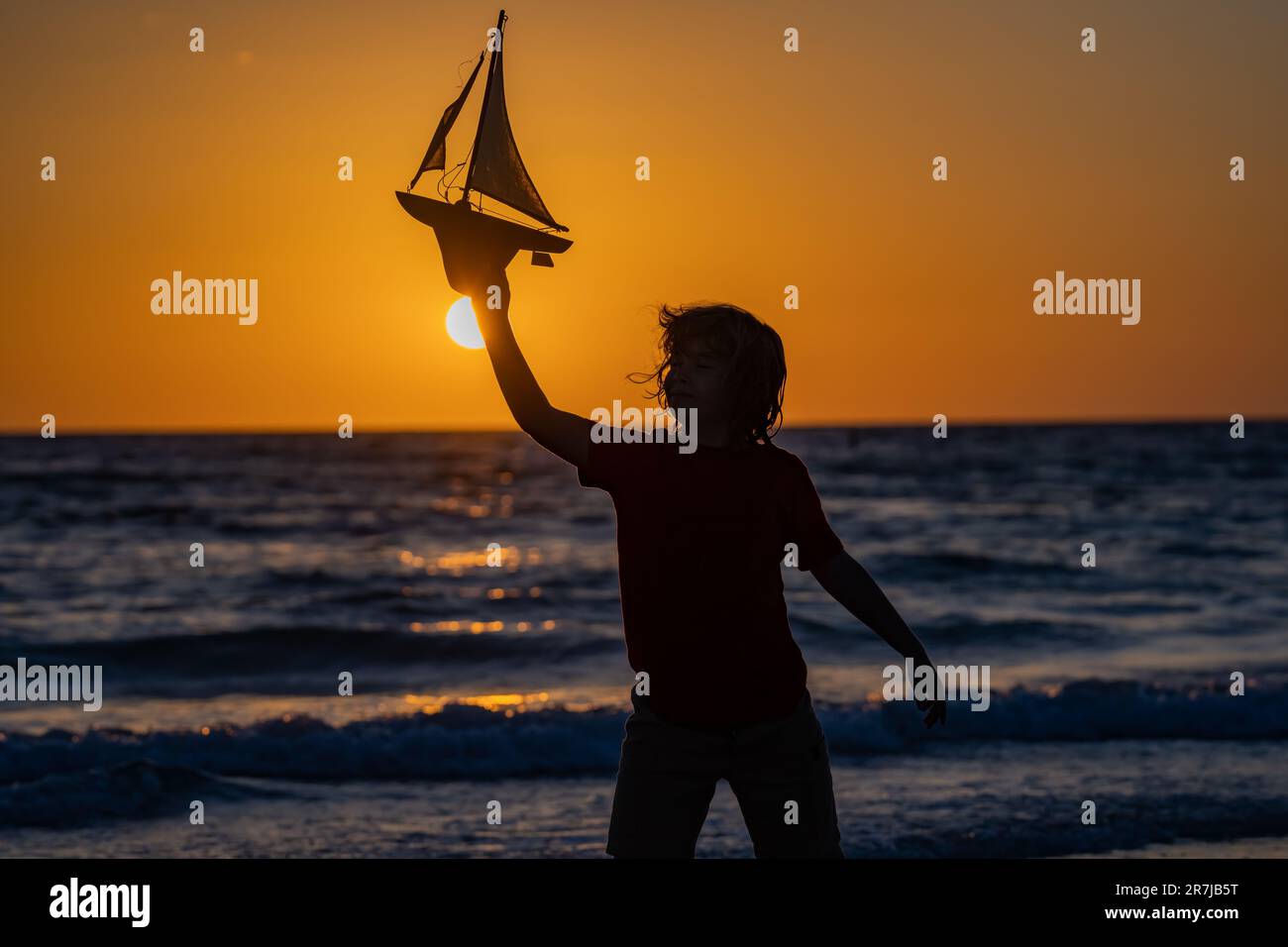 Child playing with a toy boat. Little kid boy sailing toy ship on sea ...