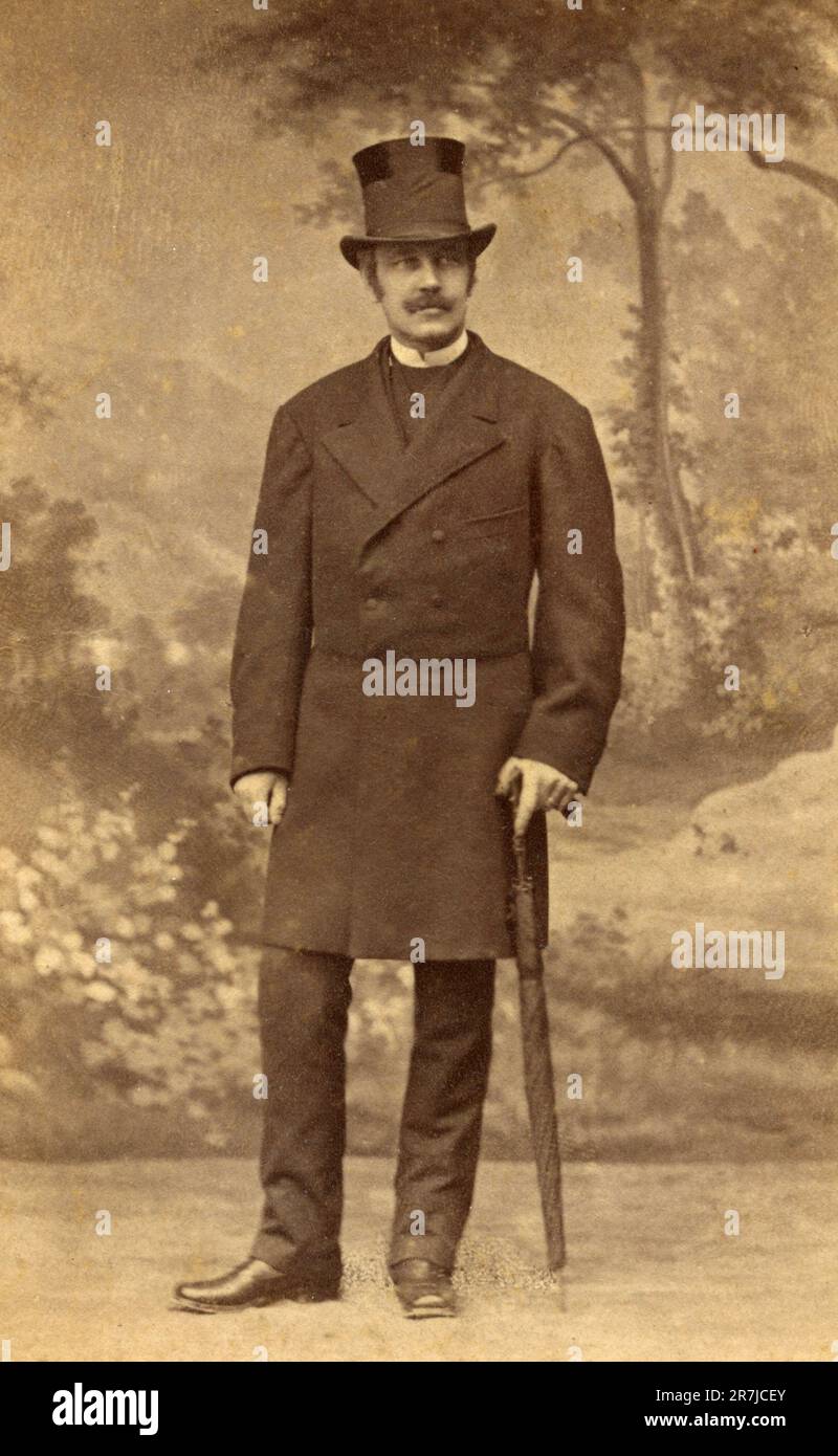 Studio portrait of a middle age gentleman standing with umbrella and ...