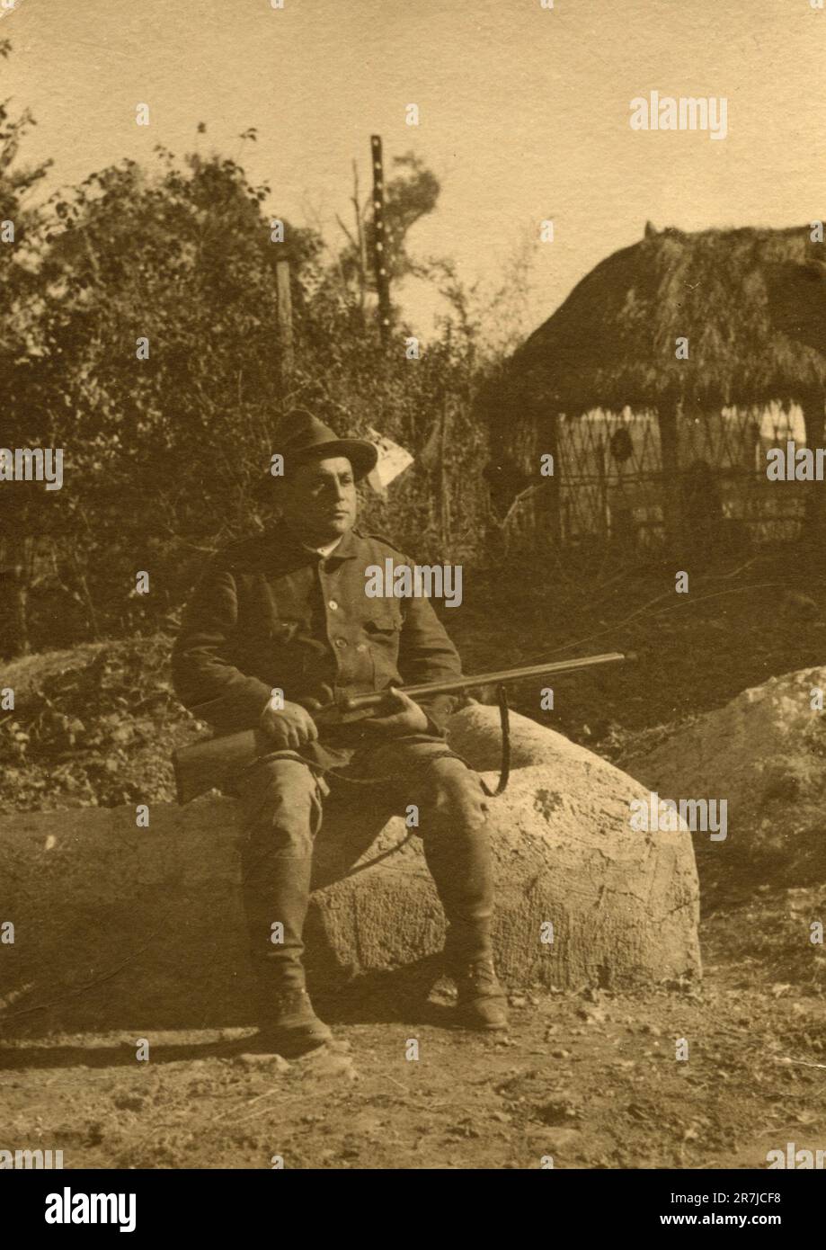 Hunter posing in a sitting position with the gun but without preys ...