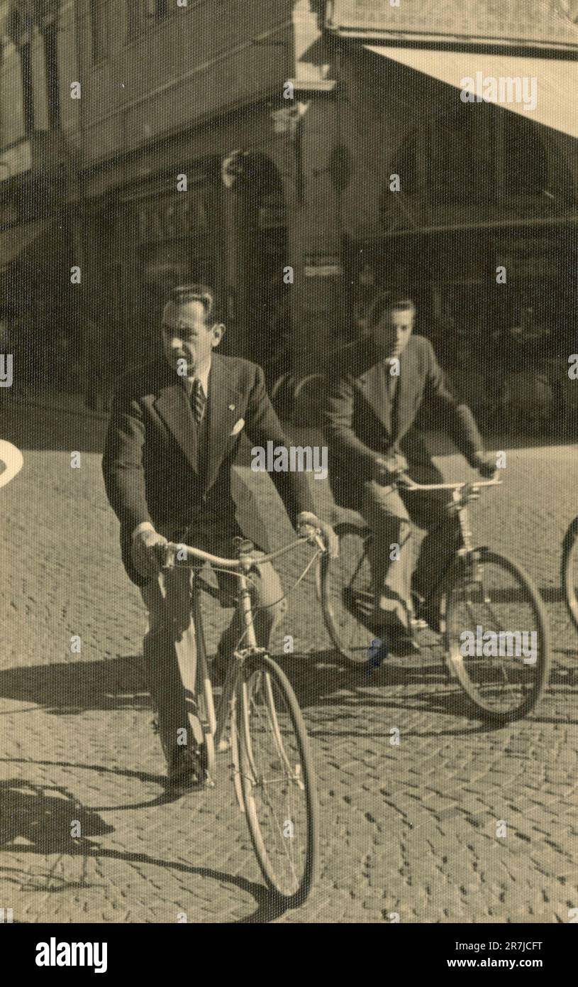 Two men riding bicycles downtown, Italy 1950s Stock Photo - Alamy
