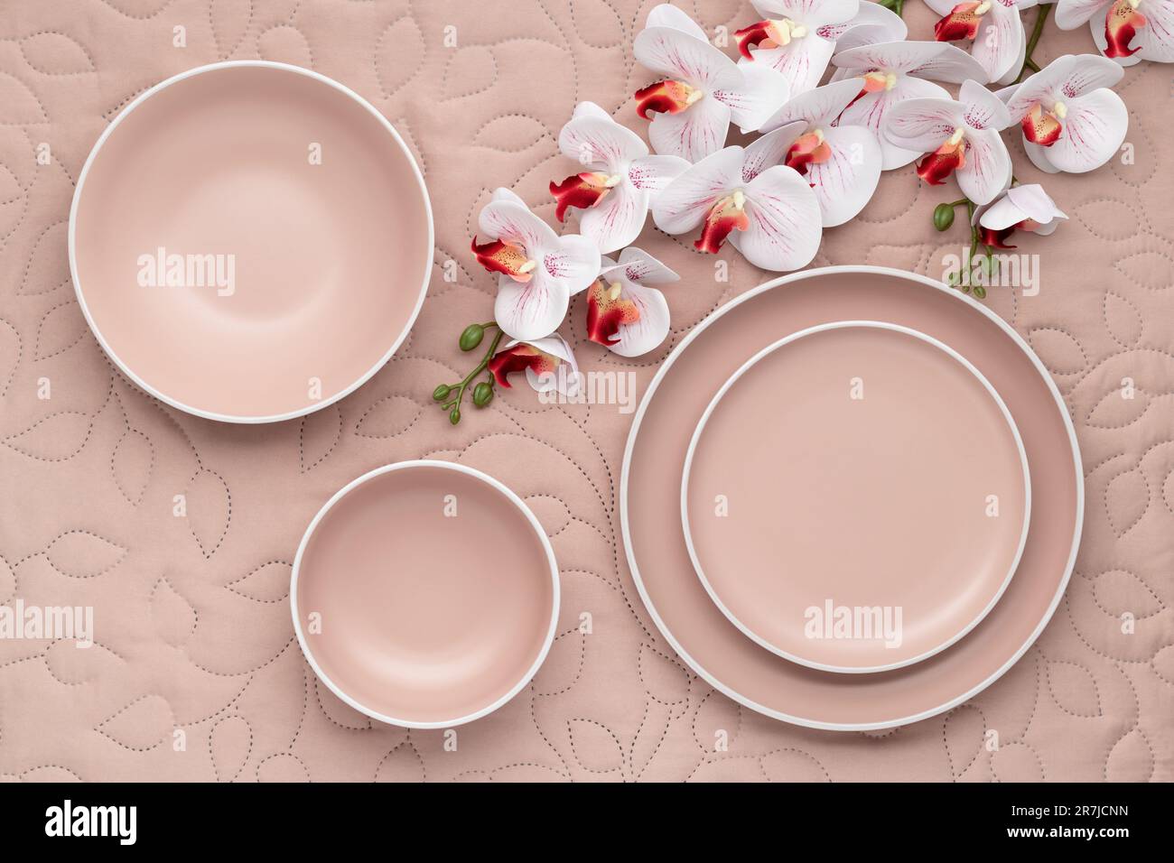 A set of cream color plates of different sizes and bouquet of flowers ...