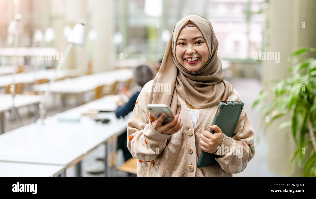 Portrait of asian muslim female student in a library Stock Photo - Alamy