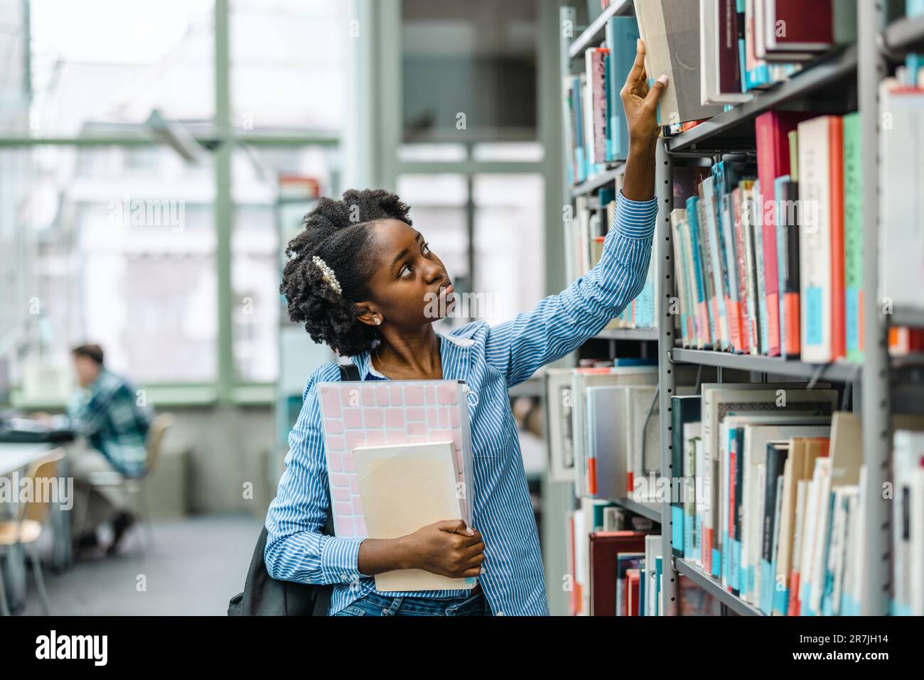 Portrait of black female student standing in a library Stock Photo - Alamy