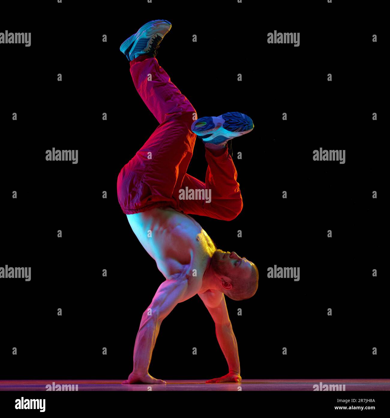 Young talented, expressive man with muscular body dancing breakdance ...