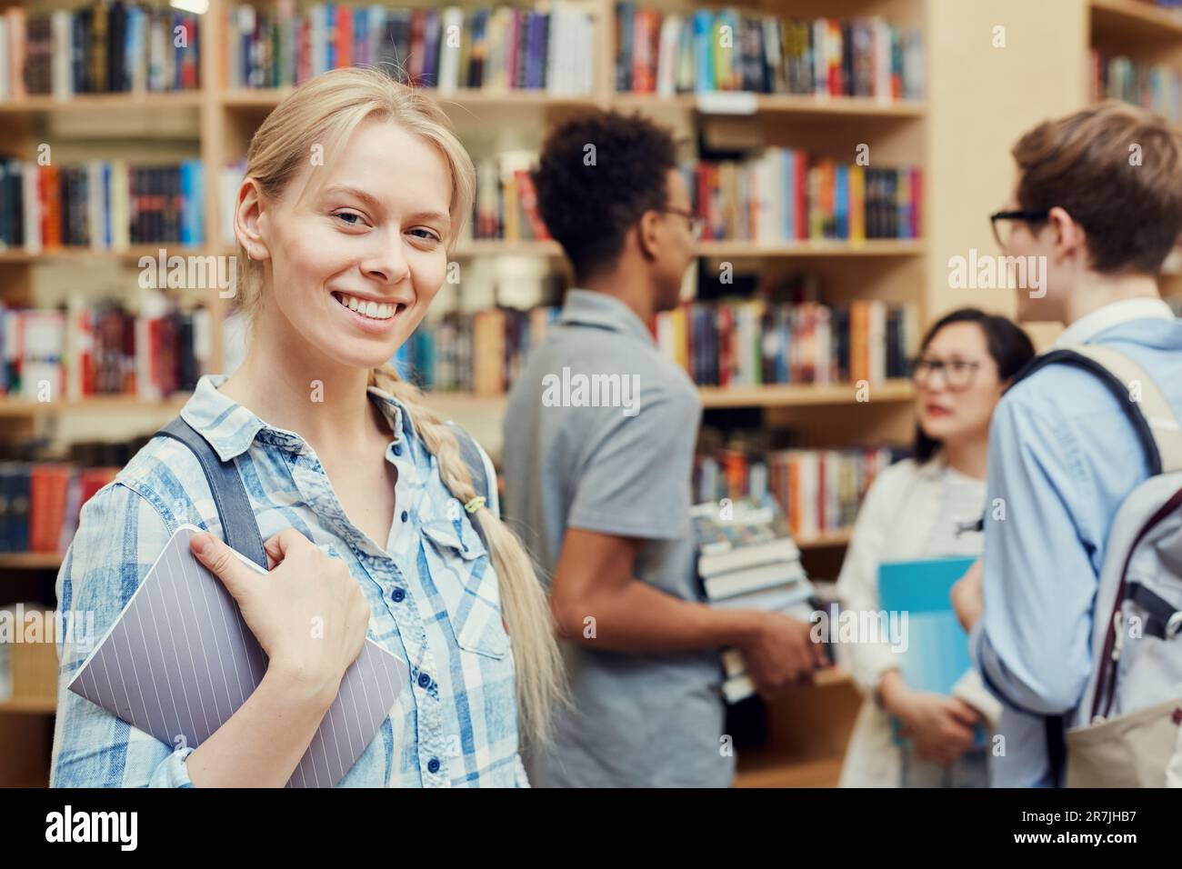 Portrait of cheerful pretty girl with blond hair standing in high ...