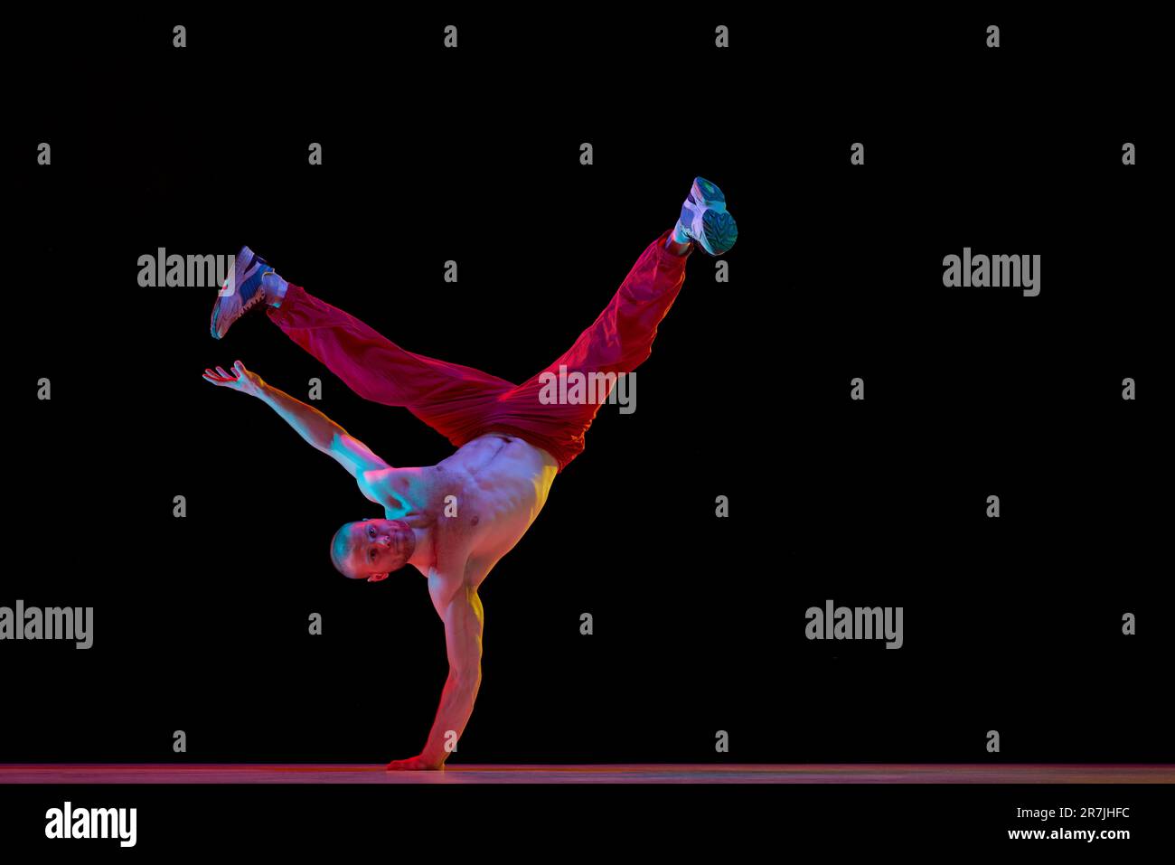 Hand spinning. Muscular, talented, active young man dancing breakdance ...