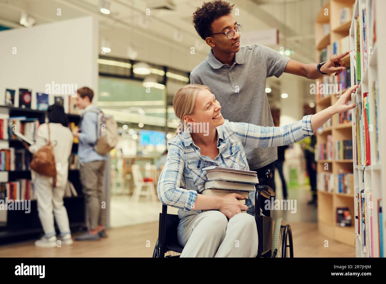 Smiling young Afro-American bookstore asking person with disability ...