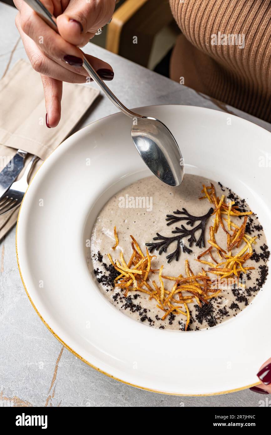 A female eating a healthy creamy breakfast at a restaurant table Stock ...