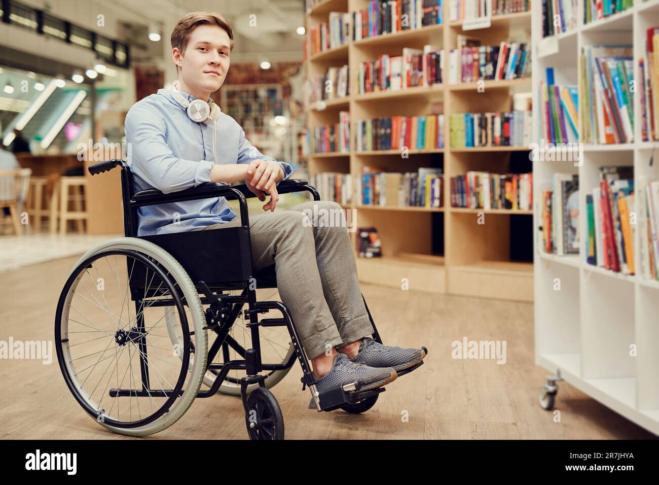 Portrait of content student boy with paralyzed legs sitting in ...
