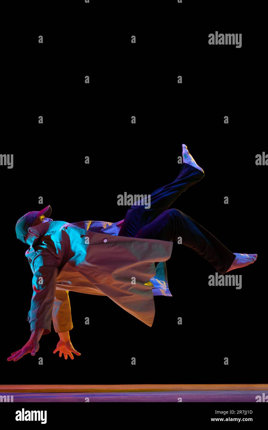 Dynamic image of young talented man in stylish clothes dancing ...