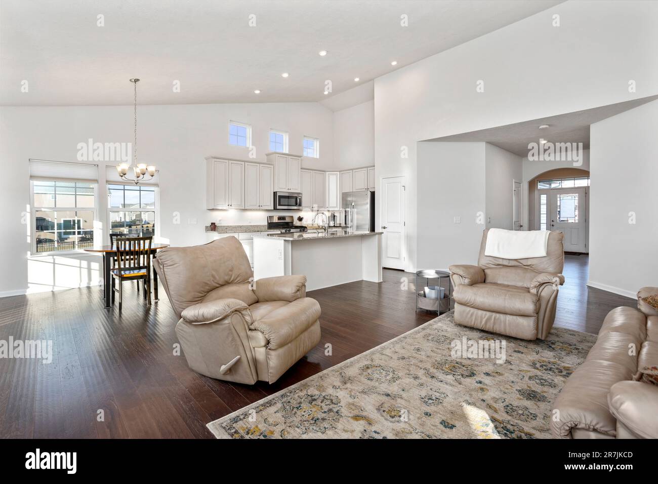 An open-plan living and dining area with two comfortable recliner ...