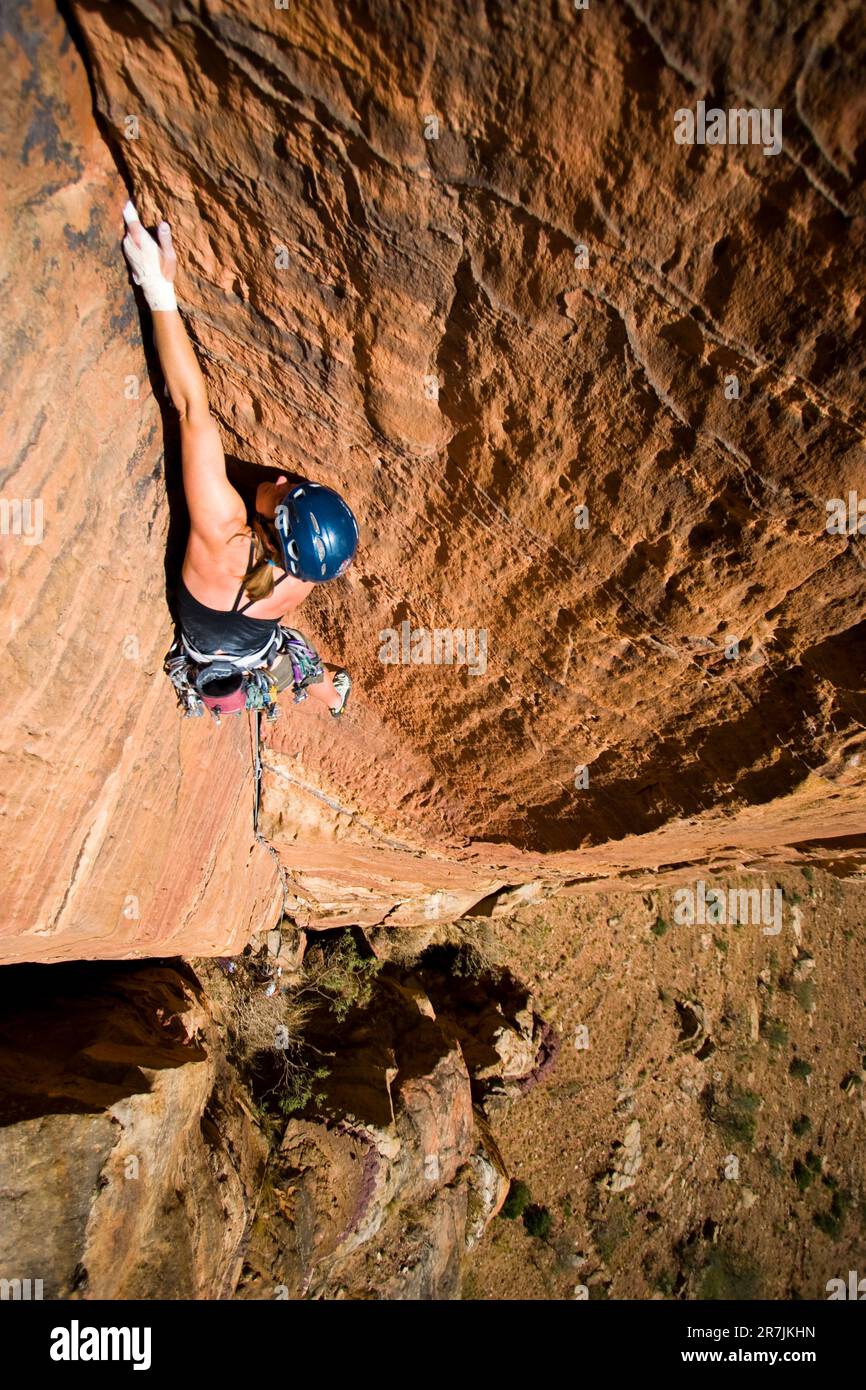 5.11 sandstone route with female climber. Crack climbing, taped hands ...