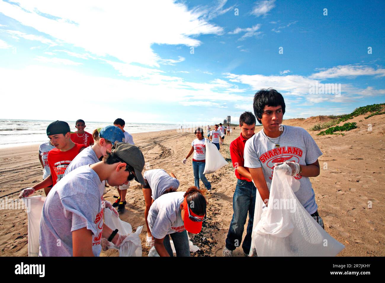 A group of high school volunteers clean up the beach on S. Padre Island ...