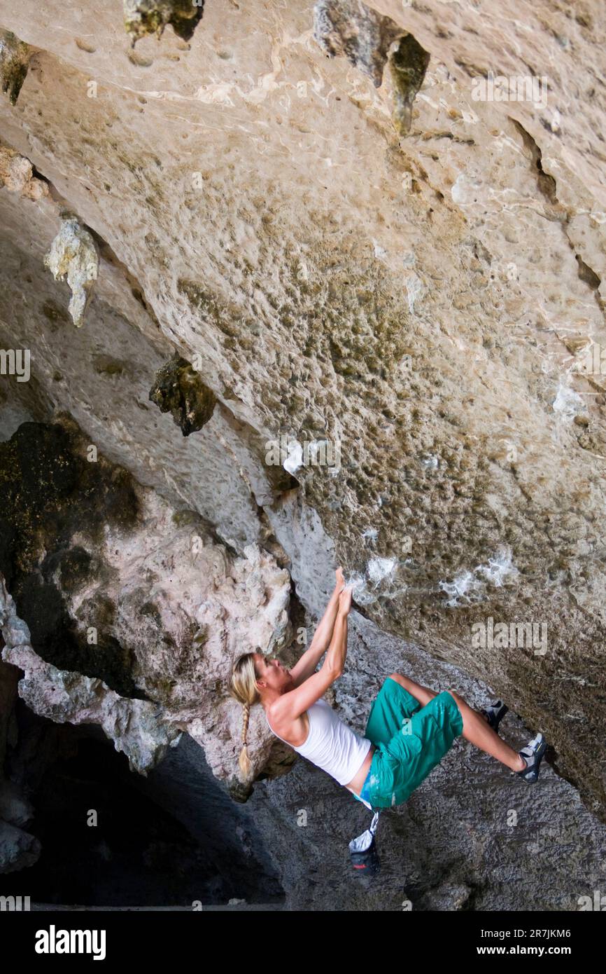 Female athlete hanging on for dear life as she works out a boulder ...