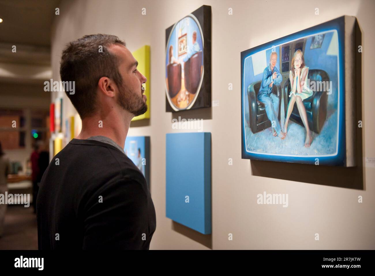 A man takes a close look at paintings in a gallery Stock Photo - Alamy