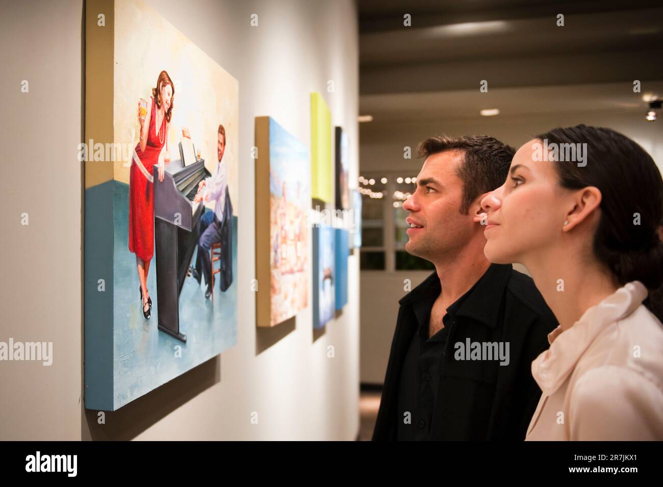 A couple take a close look at a painting in a gallery Stock Photo - Alamy