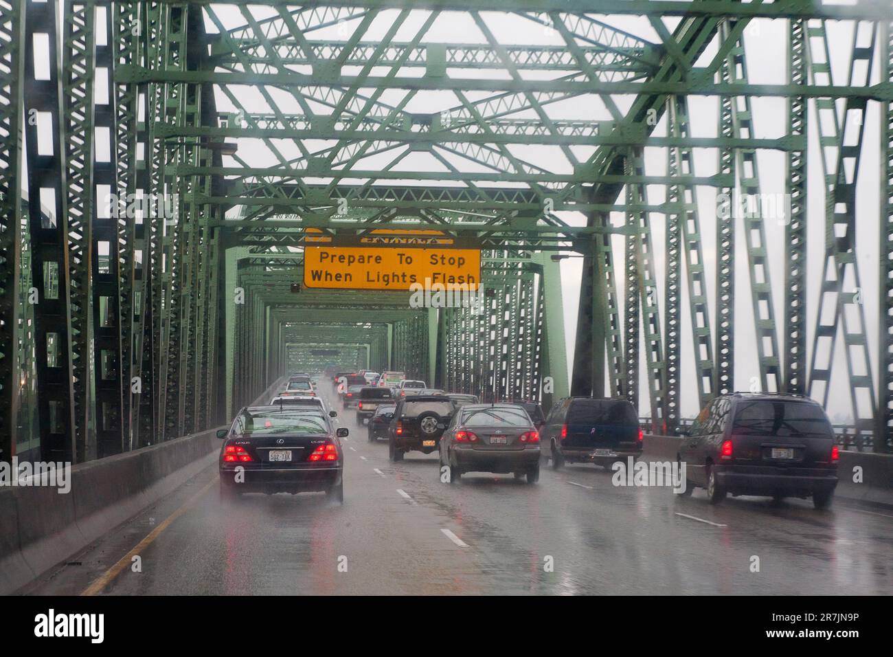 There is rain and heavy traffic on the freeway bridge which separate ...