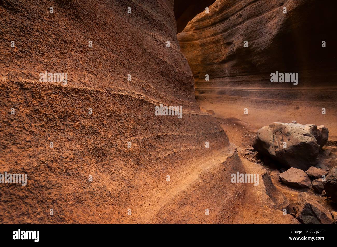 Canyon carved between rocks. With a dirt road worn by the rains Stock ...