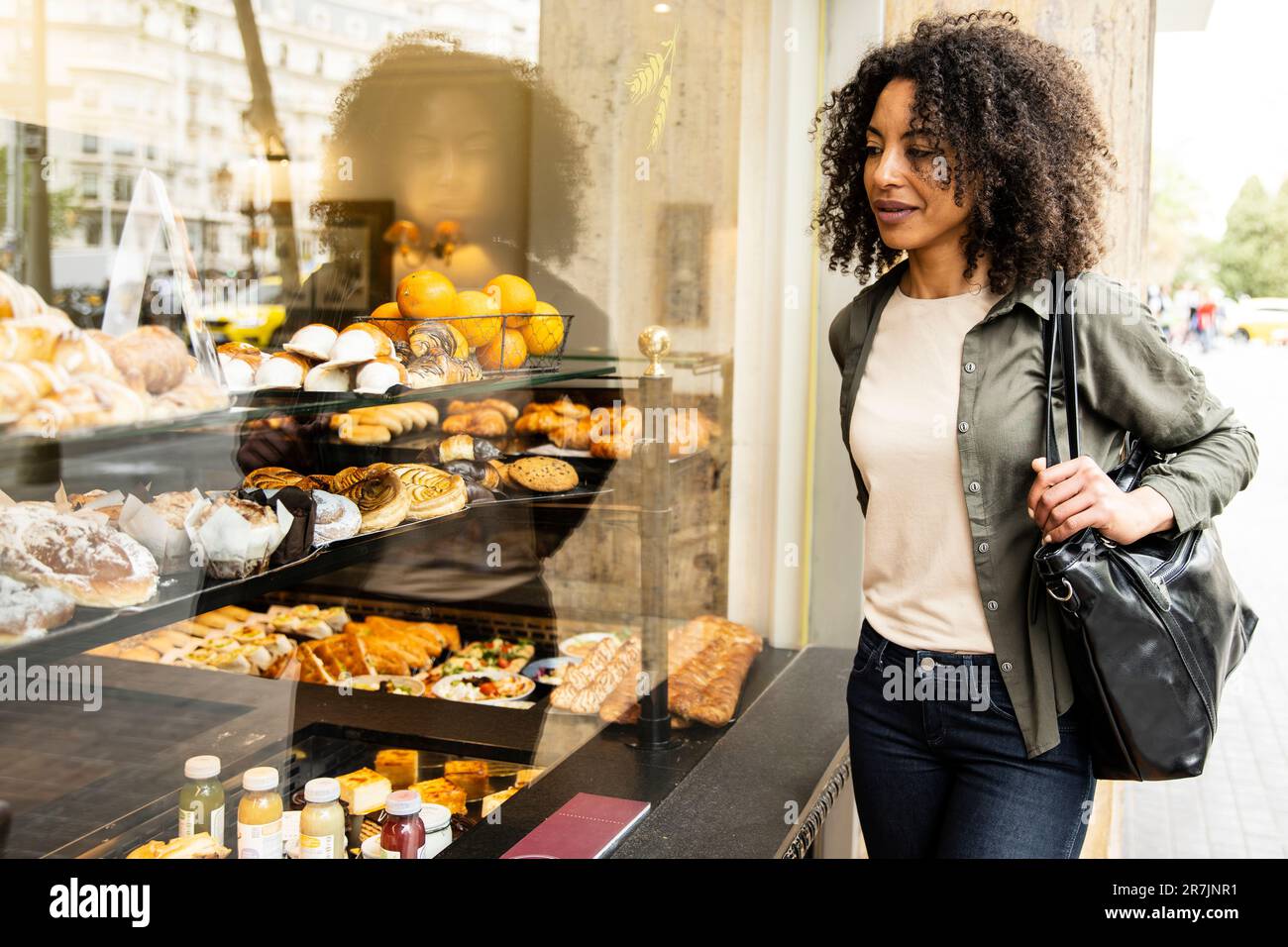 Woman looking in a bakery window from outside Stock Photo - Alamy
