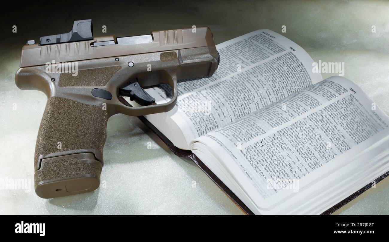 Semi-auto handgun on a bible open to the page in which Jesus tells his ...