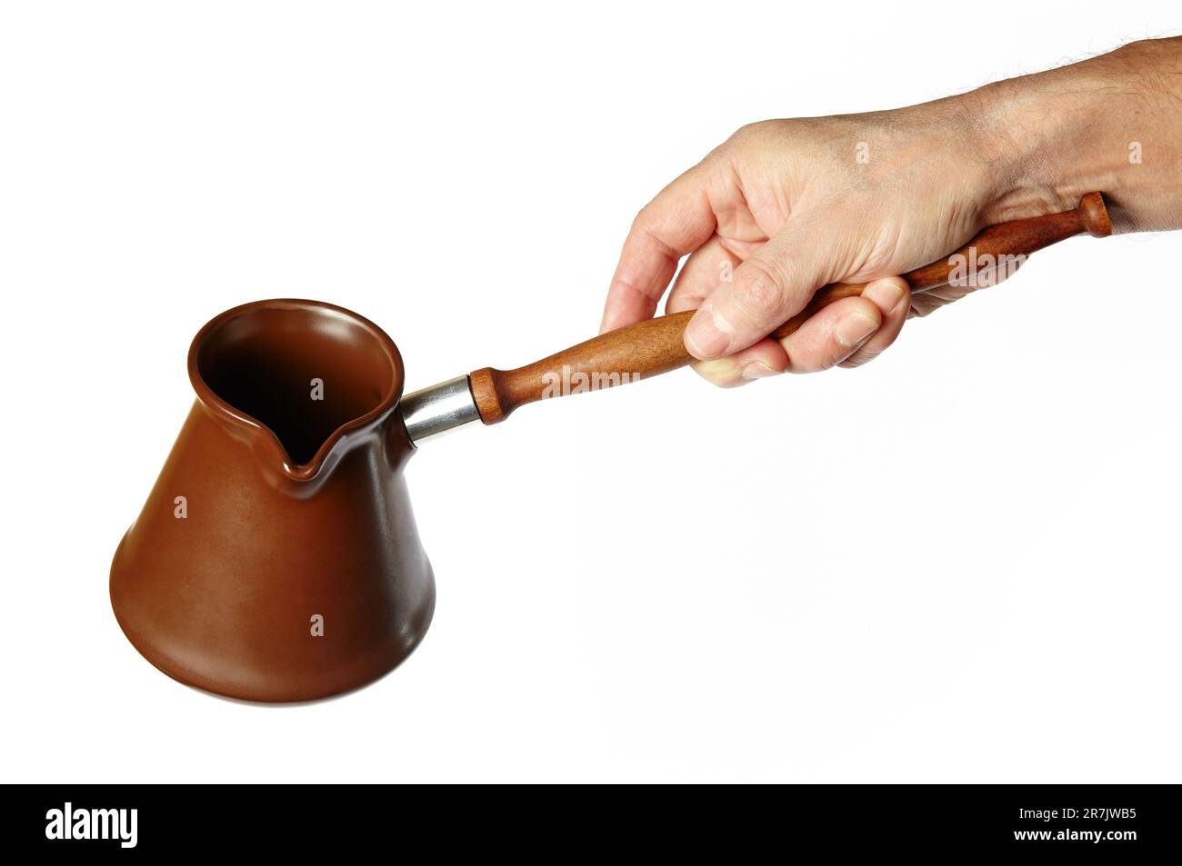 Men's hand holding coffee turk isolated white background. Clay cezve ...