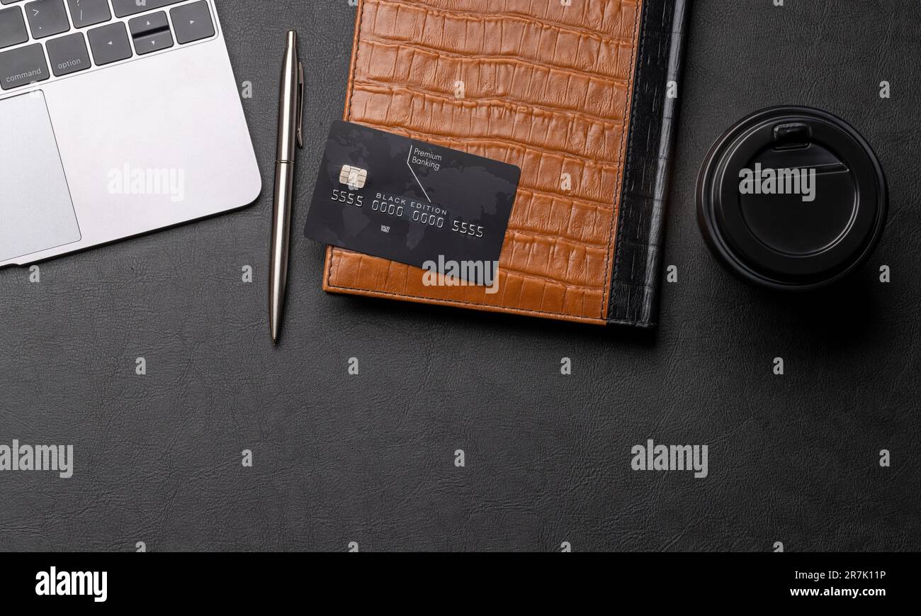Black credit card on office table with laptop and coffee cup. Flat lay ...