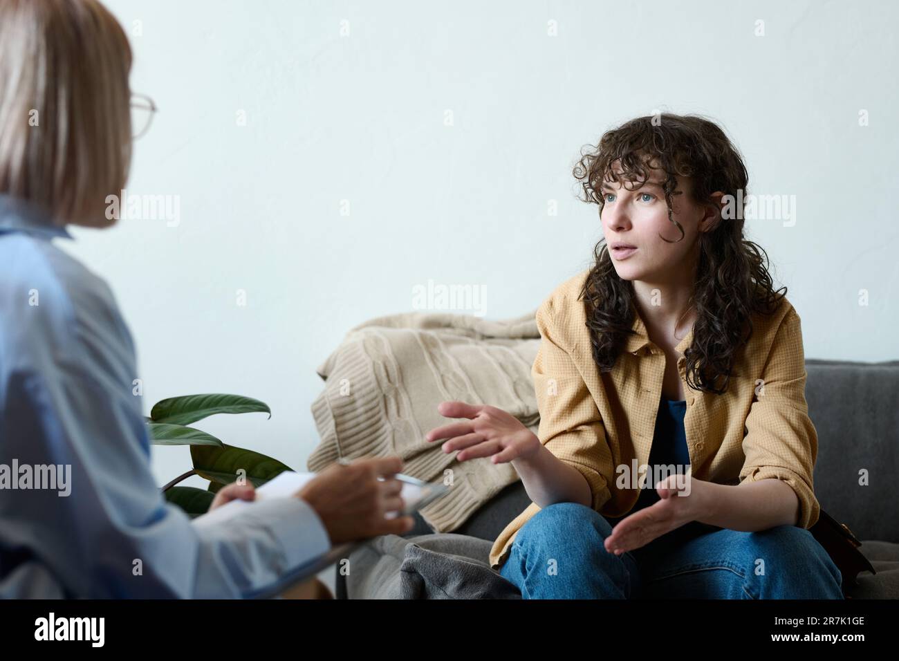 Young woman having consultation with psychologist, they sitting ...