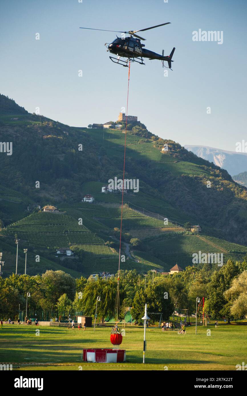 A helicopter collecting water to stop forest fires with rolling hills ...