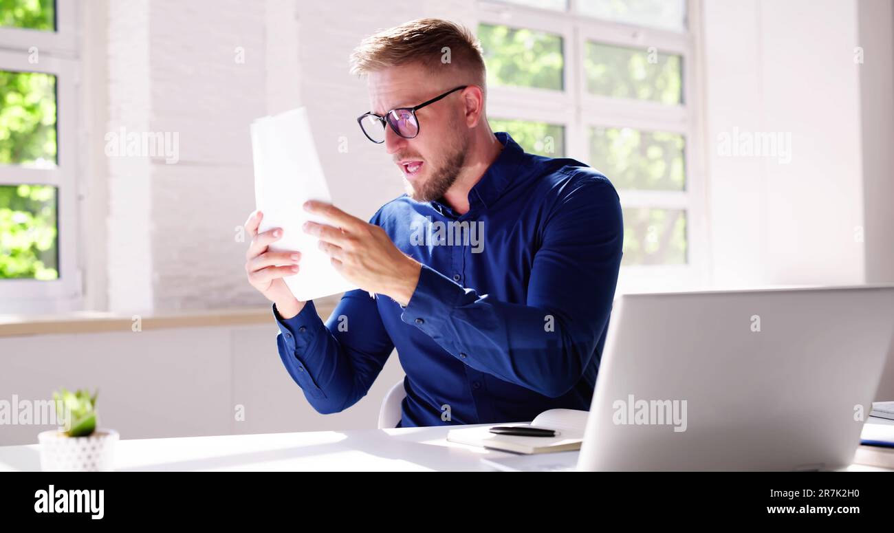 Sad Man Reading Paper Invoice With Stress Stock Photo - Alamy