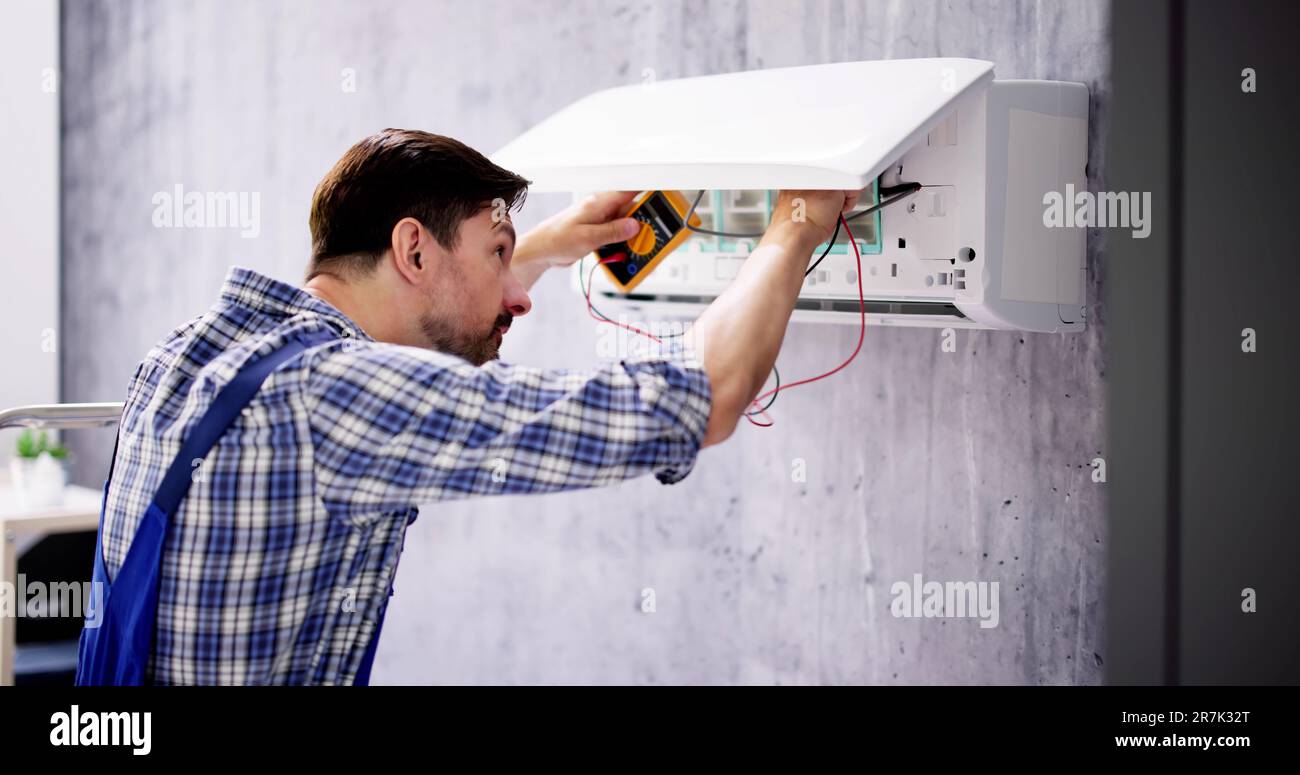 Portrait Of A Mid-adult Male Technician Testing Air Conditioner With ...