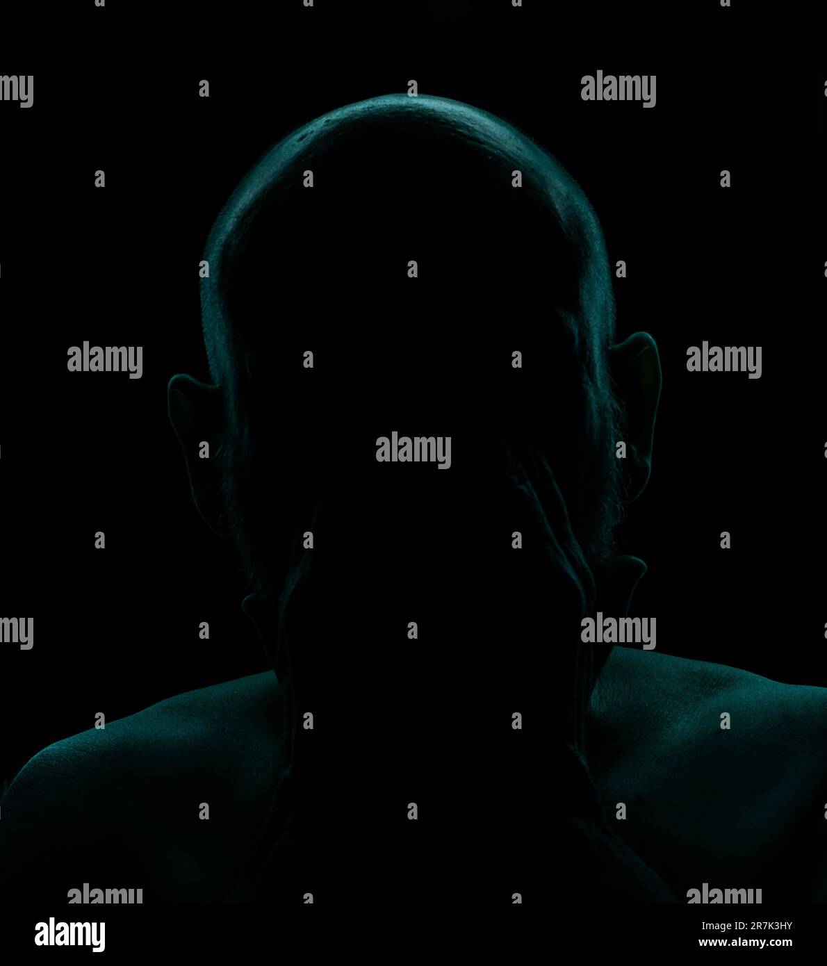 Silhouette of a man head in backlight. Low light portrait with cyan ...