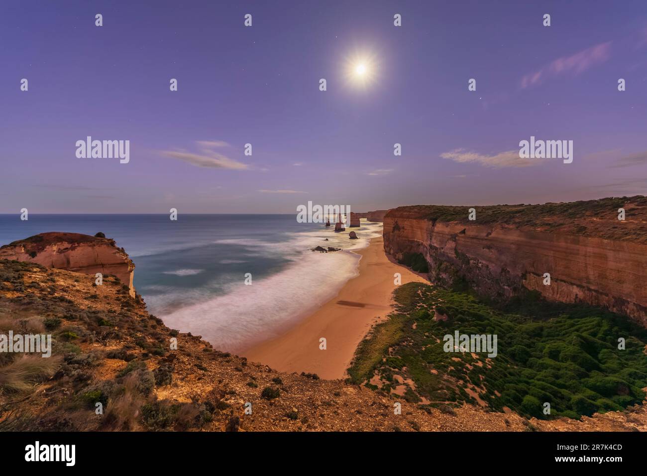 Australia, Victoria, Long exposure of moon glowing over sandy beach in ...
