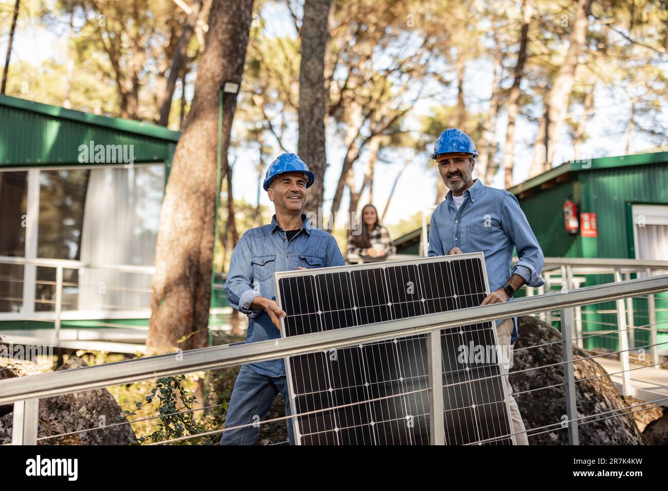 Photovoltaic technicians carrying solar panel together Stock Photo - Alamy