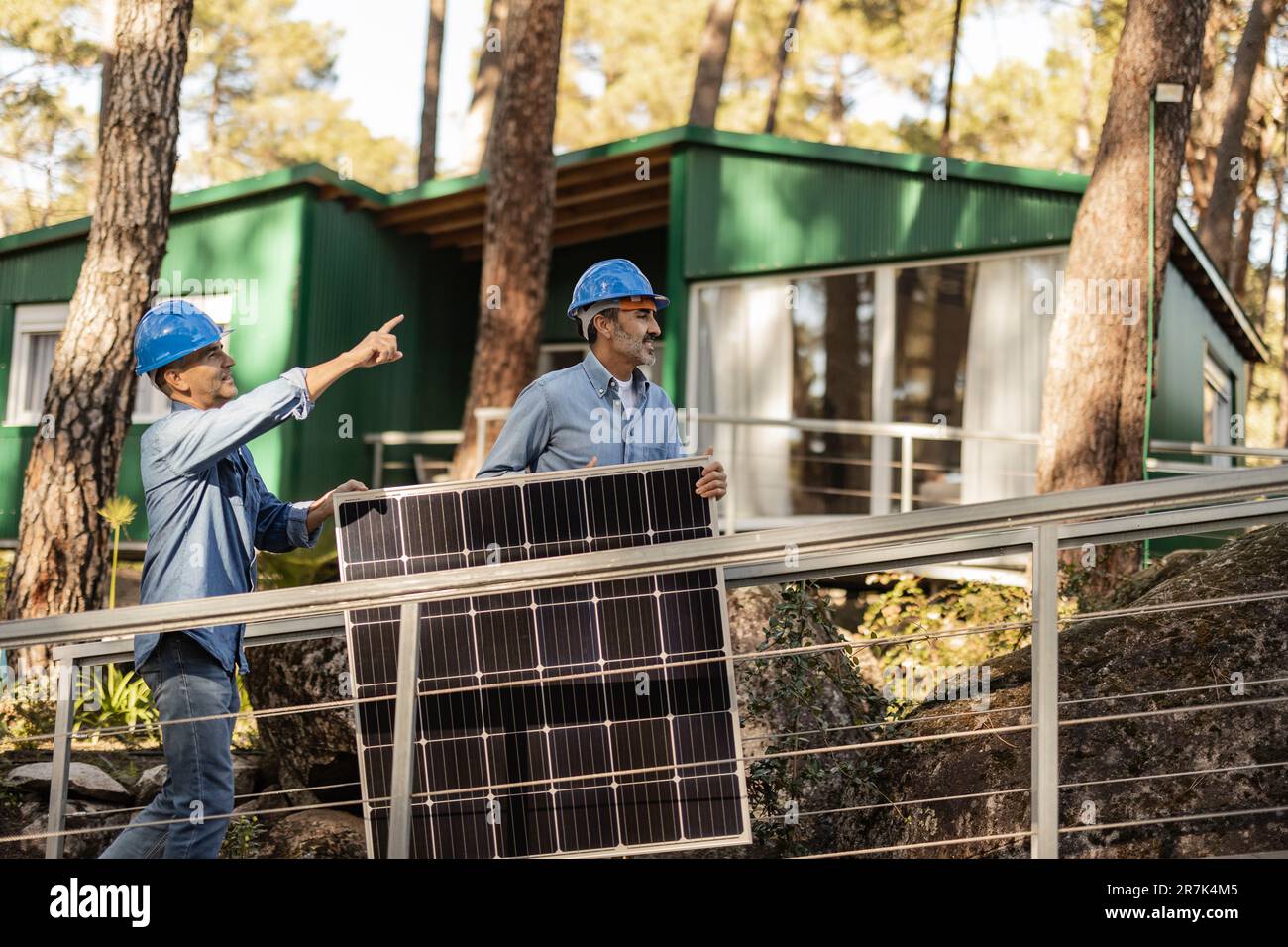 Photovoltaic technicians carrying solar panel together Stock Photo - Alamy