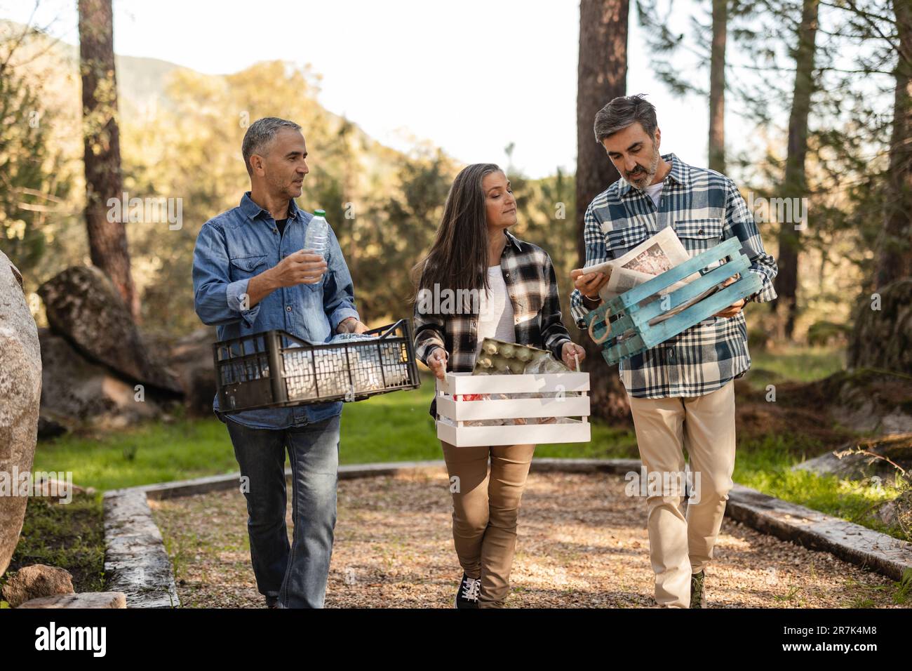 Friends carrying crates with separated waste Stock Photo - Alamy