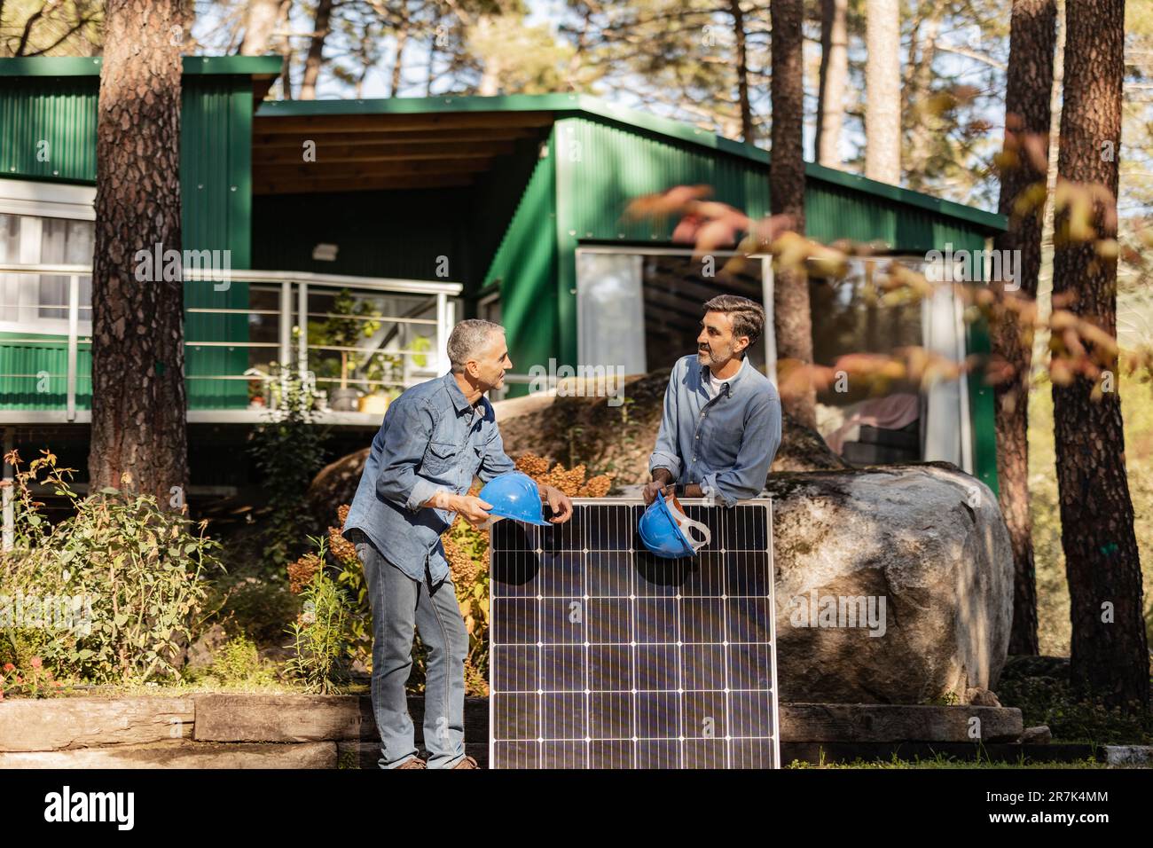 Talking photovoltaic technicians leaning on solar panel Stock Photo - Alamy
