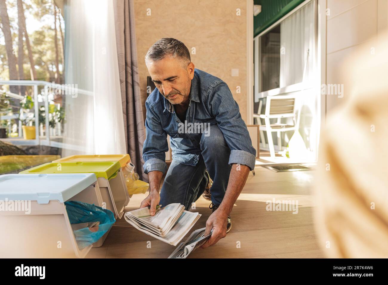 Man sorting waste into waste separation bin Stock Photo - Alamy