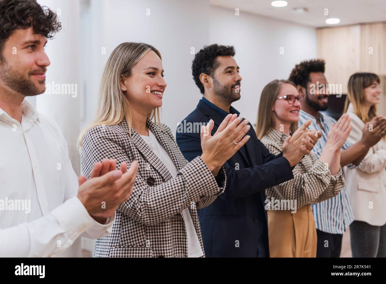 Happy business people clapping hands after a presentation in office ...