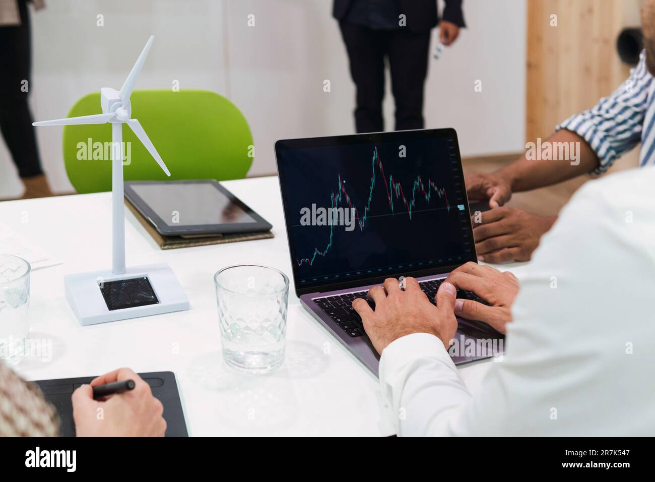 Businessman using laptop with line graph on screen during a meeting in ...
