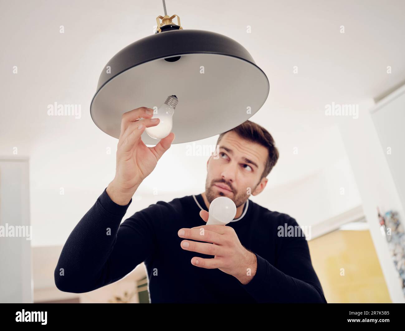 Man changing old lightbulb for a LED energy saving lightbulb Stock ...