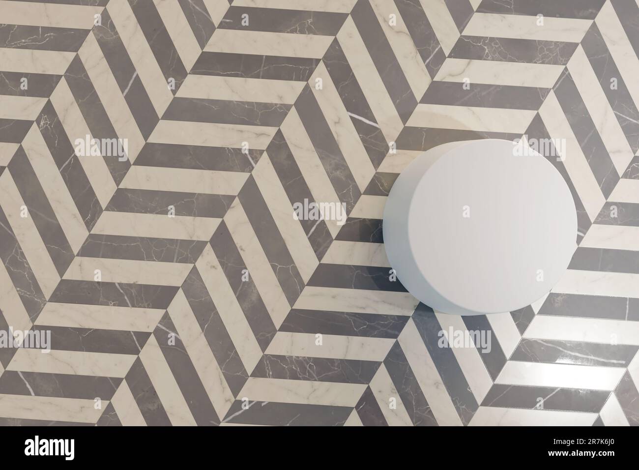 A white circular chair on a checkered wall design Stock Photo - Alamy