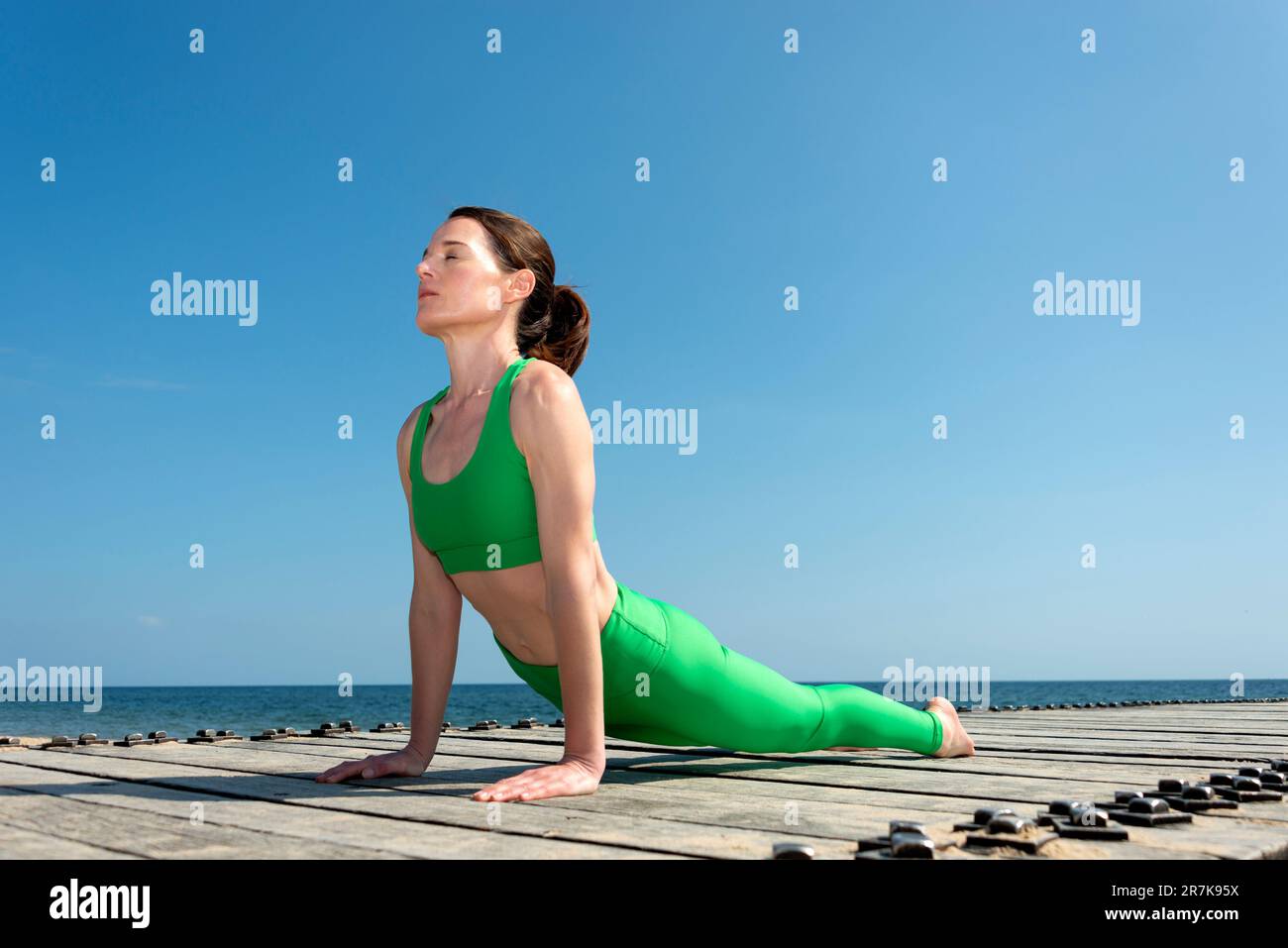 Fit woman practices yoga asana urdhva mukha svanasana - upward facing ...