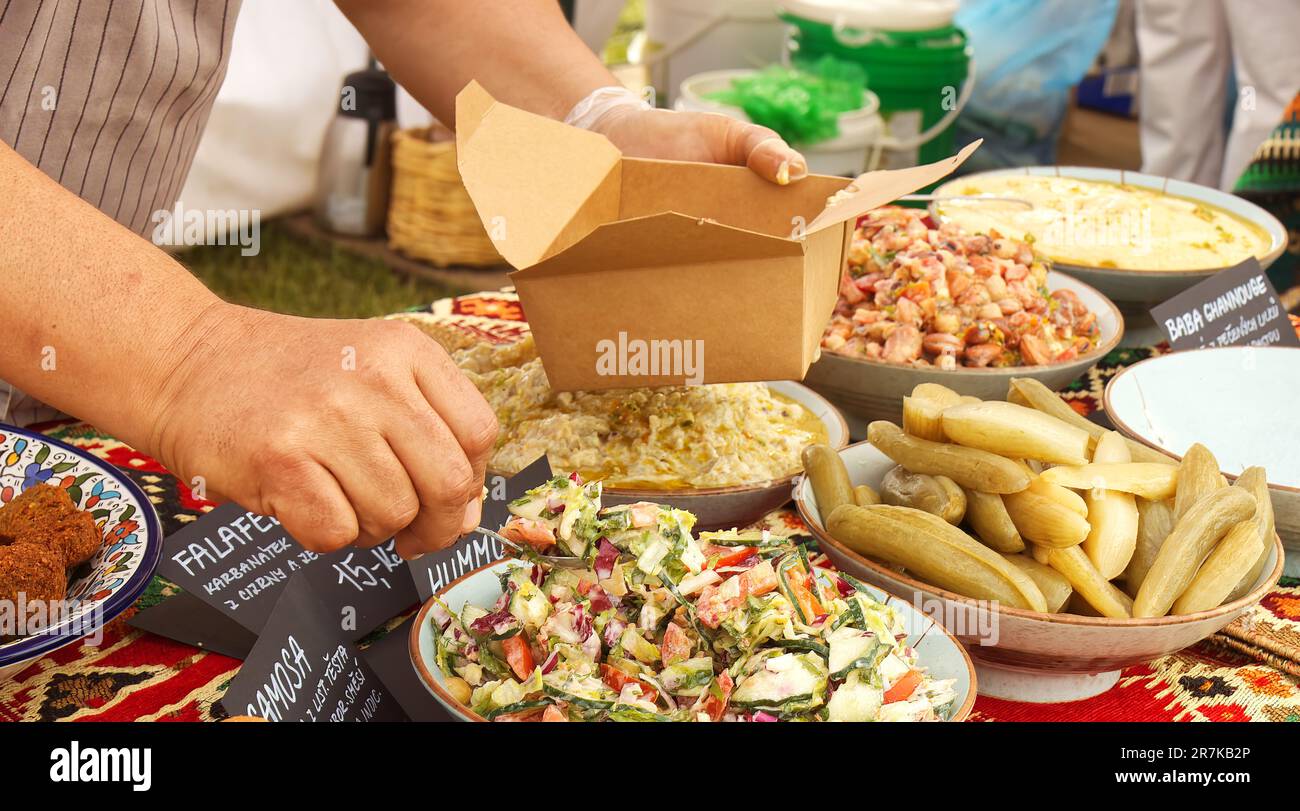 A man at a traditional Palestinian food stall prepares a snack box for ...