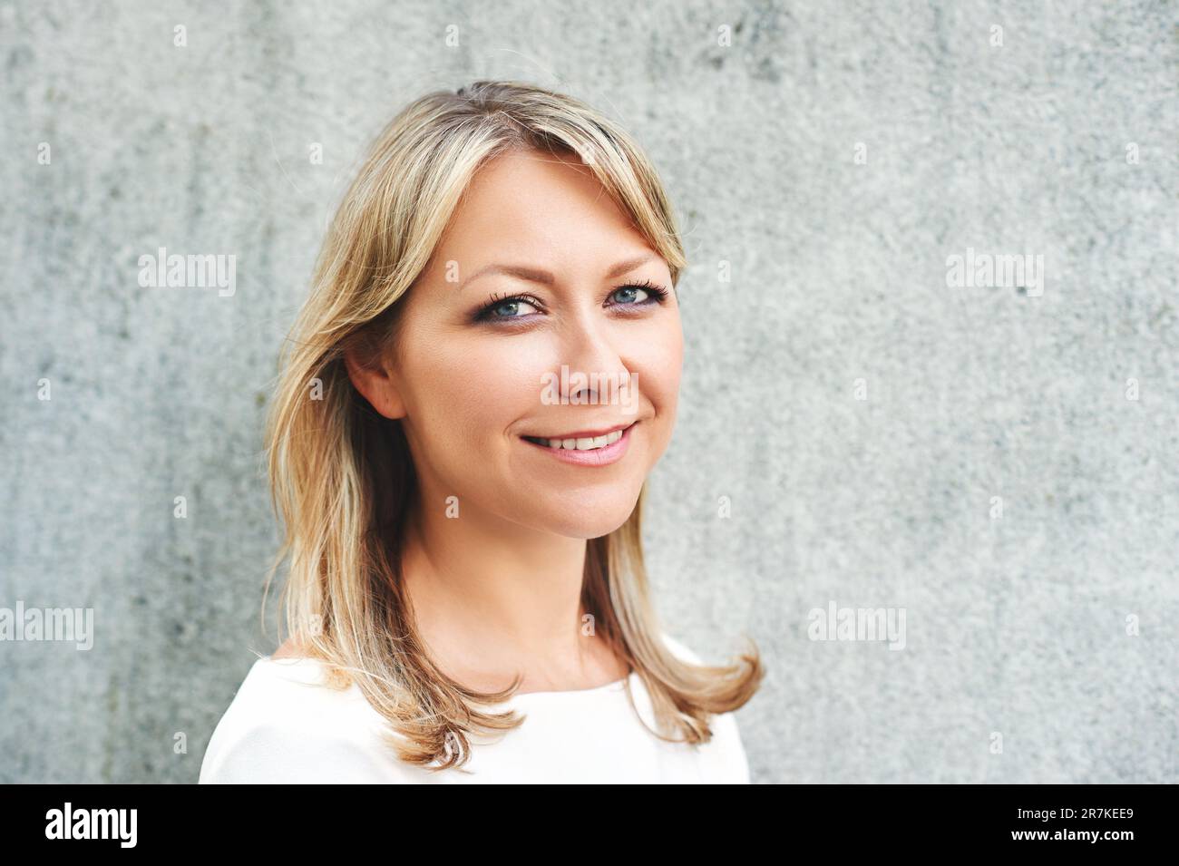 Outdoor close up portrait of middle age woman posing next to grey background Stock Photo - Alamy