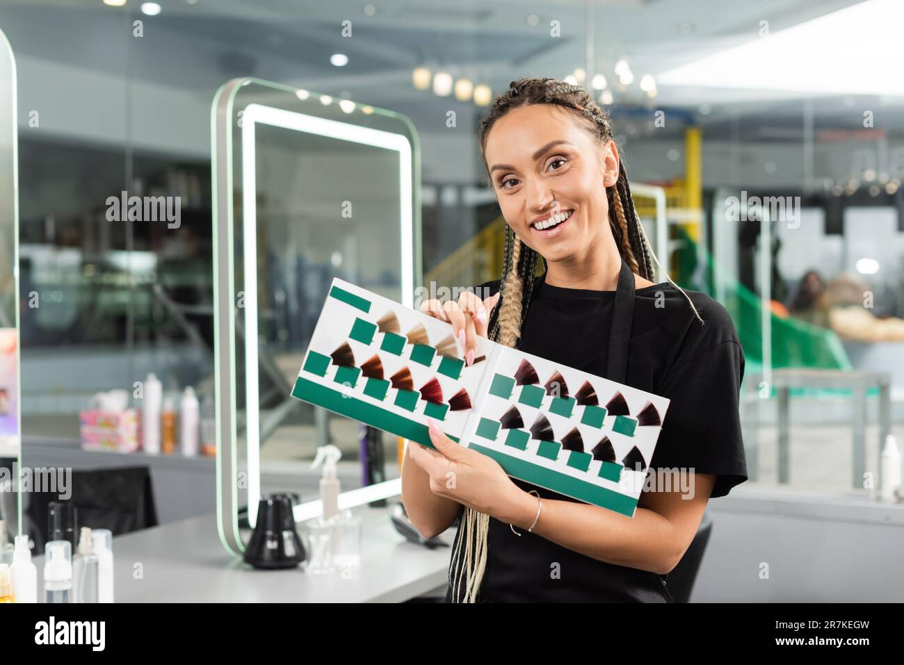 happy hair professional, hairstylist with braids choosing color while ...