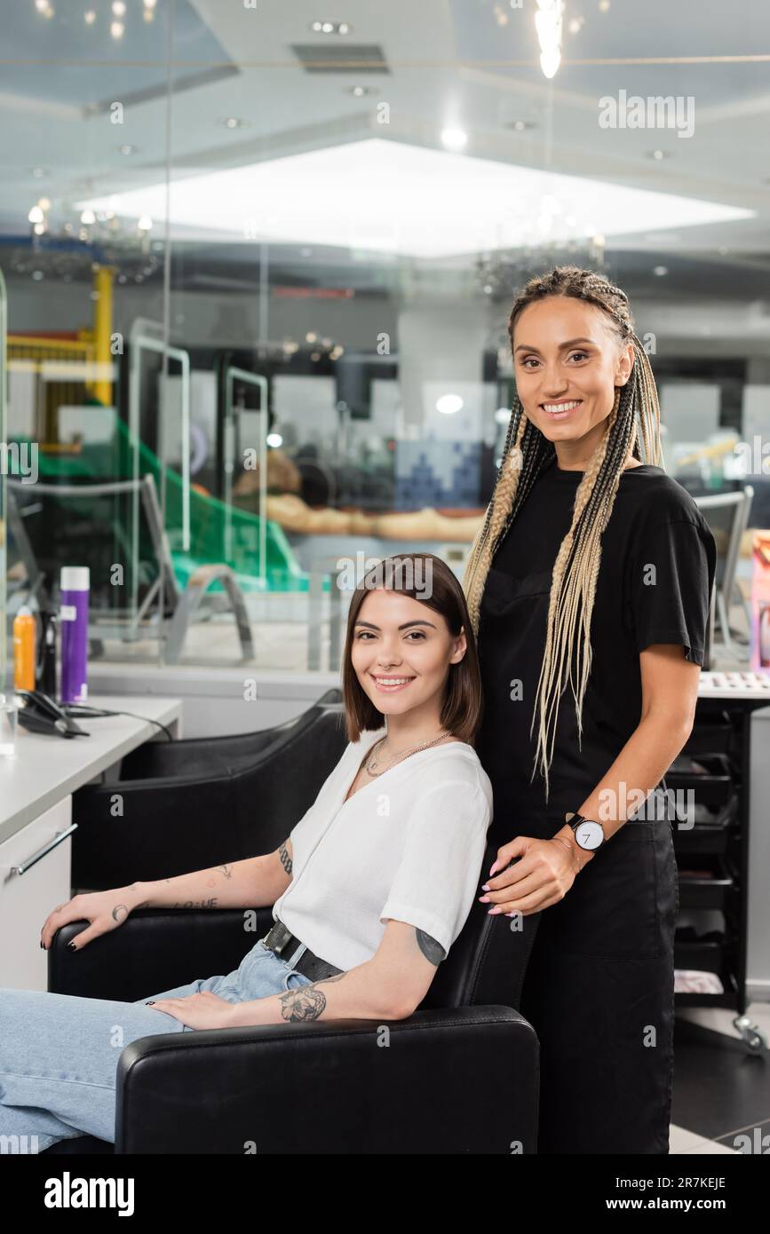 happy hair stylist and female client in beauty salon, beauty worker ...