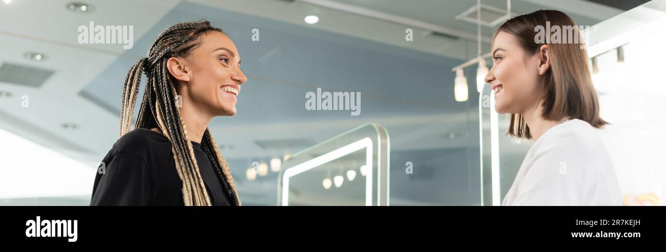 happy beauty worker welcoming female client, cheerful hair stylist with ...