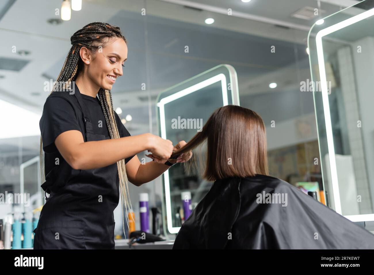 haircut, positivity, professional hairdresser with braids cutting short ...