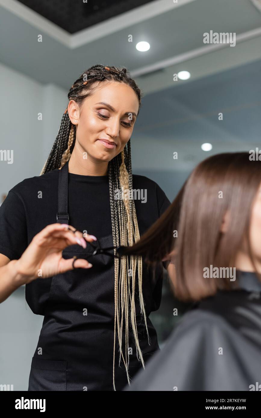hairdo, positivity, hairdresser with braids cutting short brunette hair ...