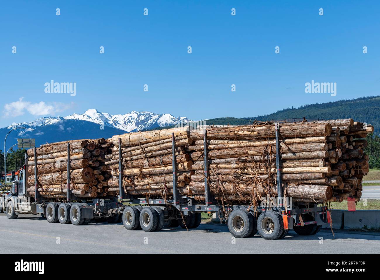 Close up of a long and loaded logging truck on a road in British ...